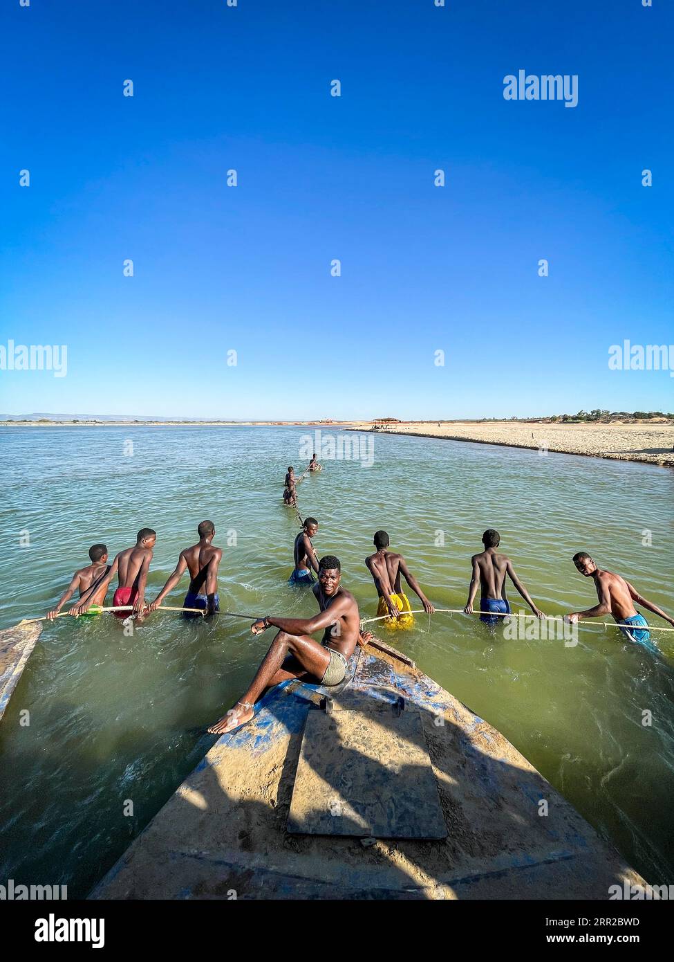 Madagascar, Tsiribihina river, young men tow barge on river Stock Photo ...