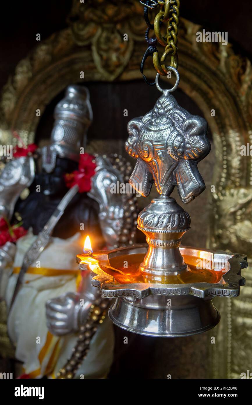 Oil lamp and statue in the Indian temple of Victoria, Mahé island ...