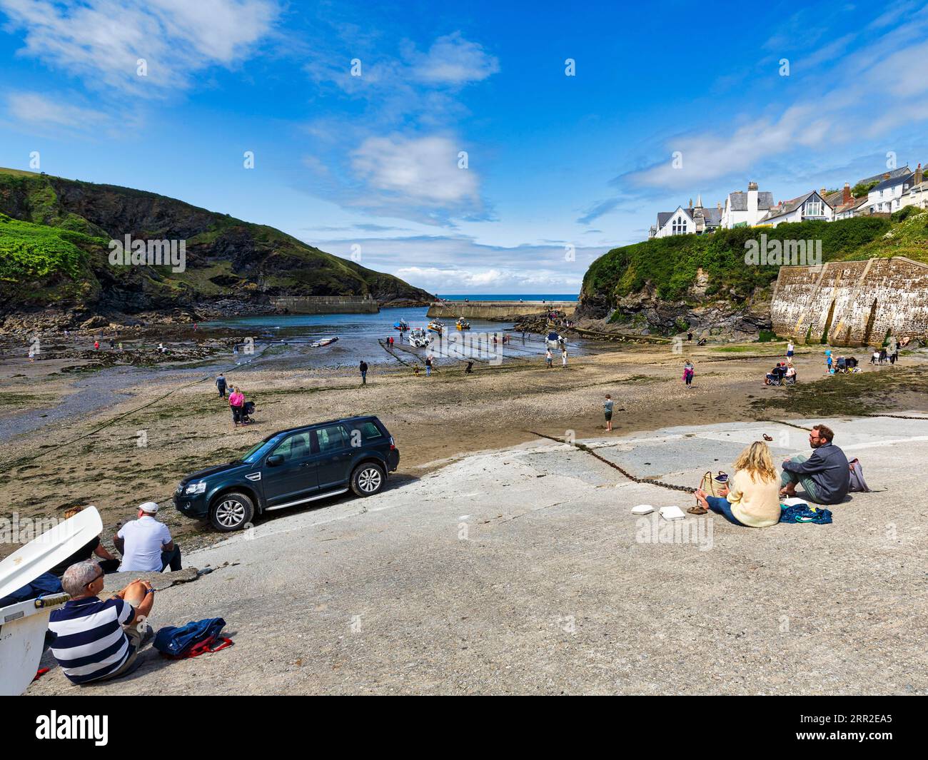 Pedestrians in the harbour at low tide, tourists in the fishing village ...
