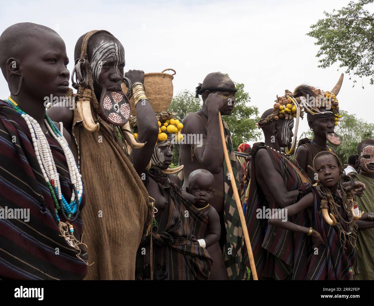 Group, men, woman and children from the Mursi tribe, traditional dress ...