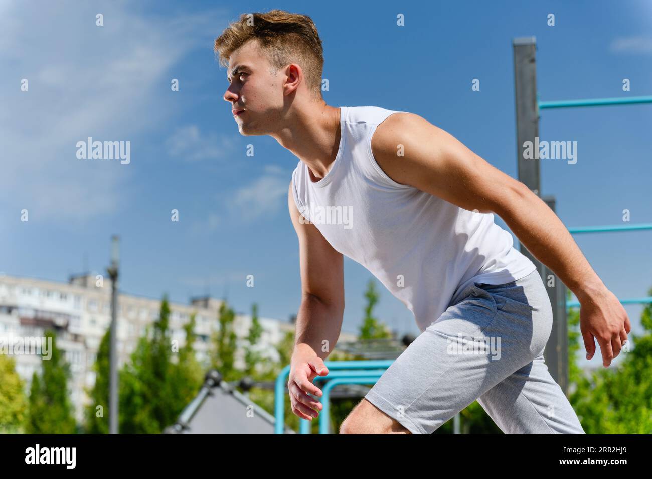 Shot of a man running from a crouched position against an sports ground ...