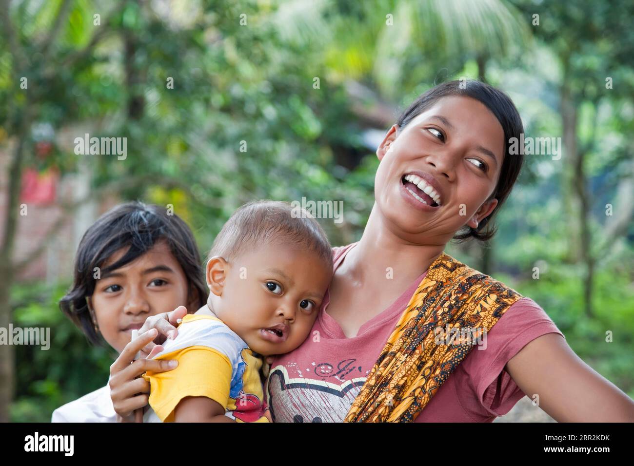 Mother, laughing, with infant and another child, Lombok, Indonesia ...