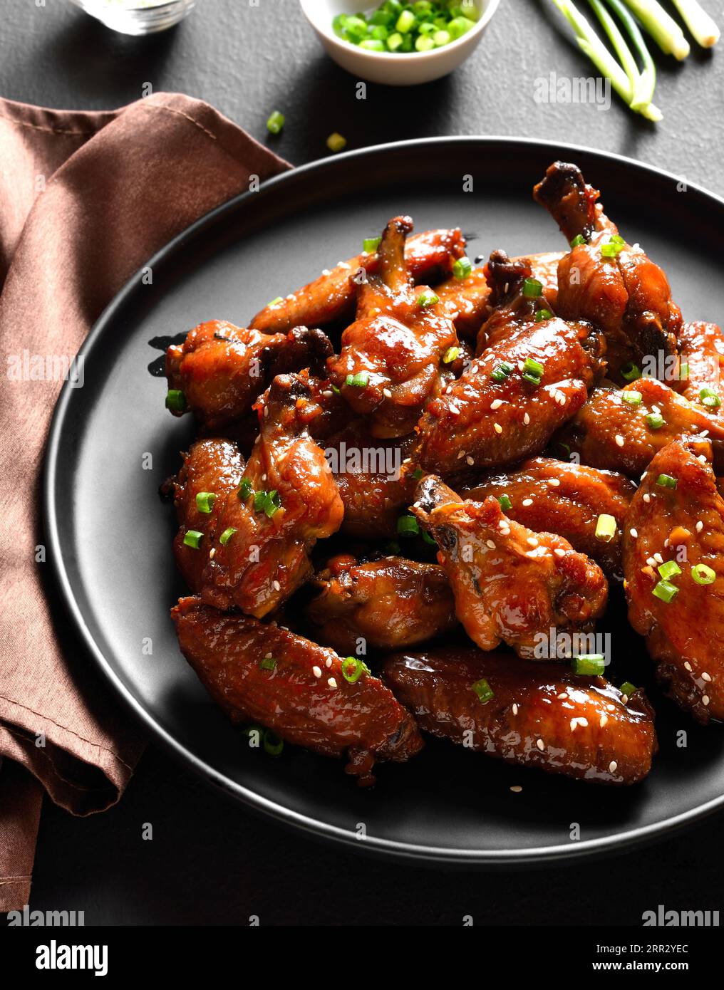 Sweet and spicy chicken wings on plate over dark stone background ...
