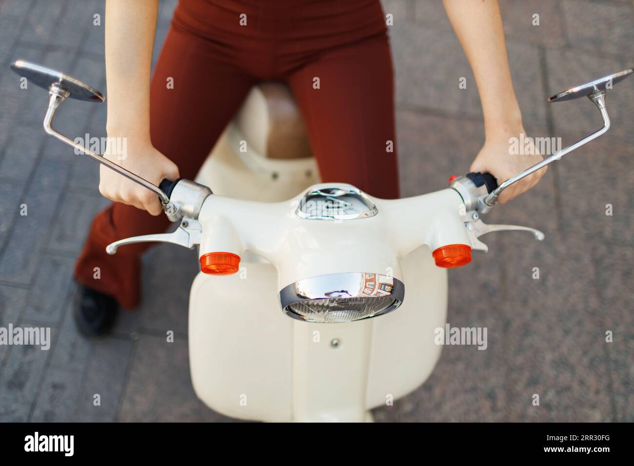 Young blond woman model riding on motorbike moped scooter in city ...