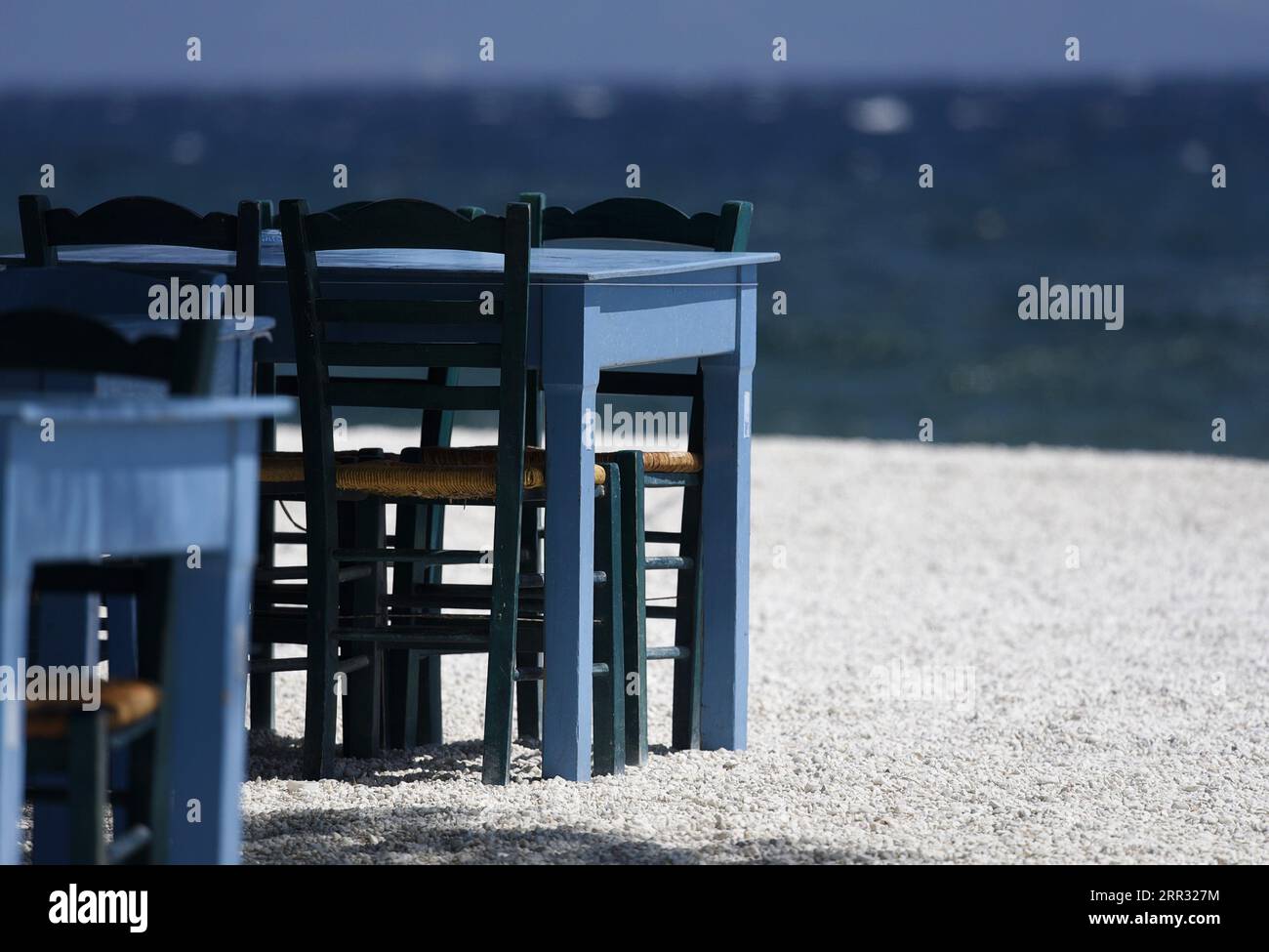 Local Greek taverna wooden tables and wicker chairs by the shore in ...