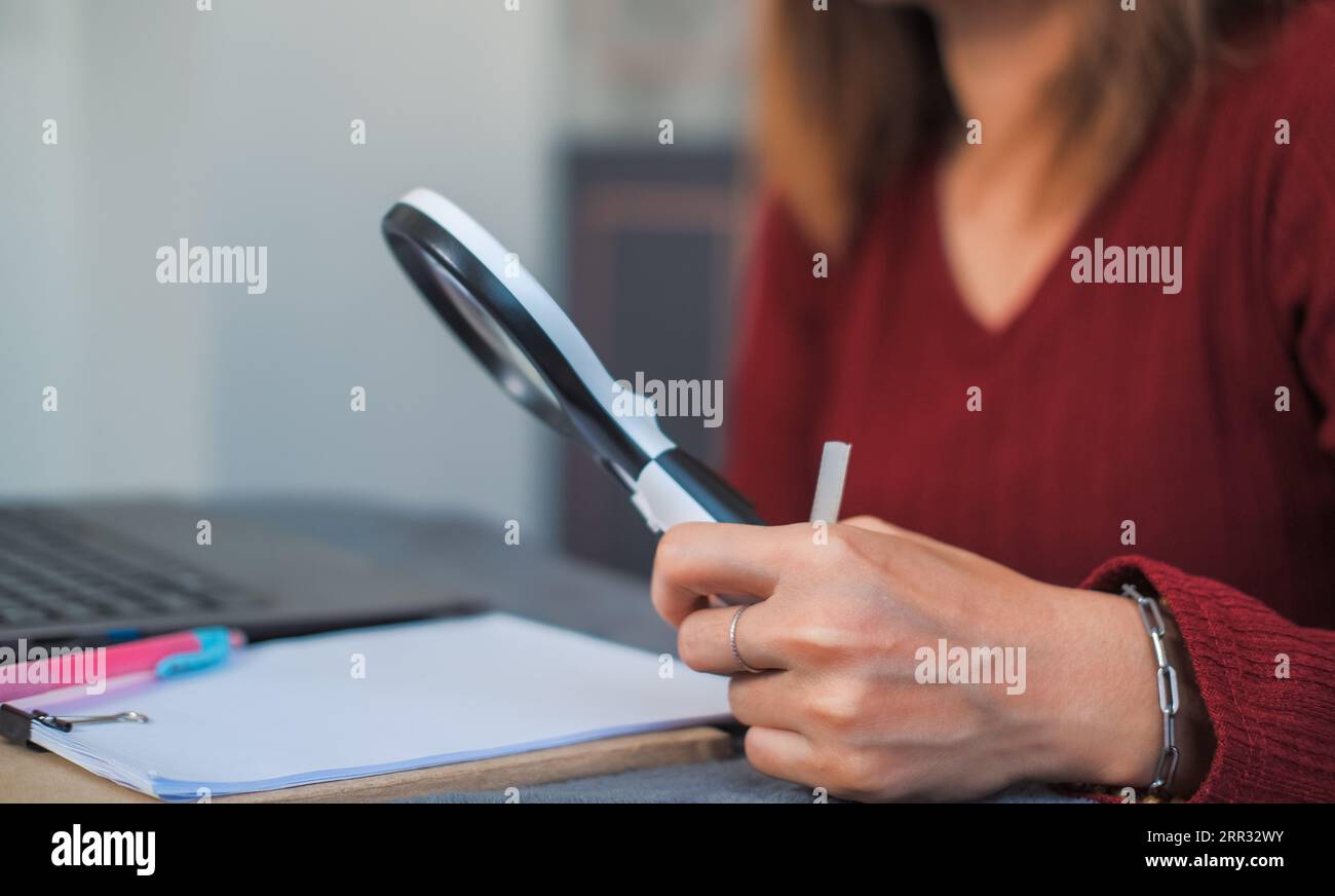 woman doing work and using a magnifying glass to look at data Suitable ...