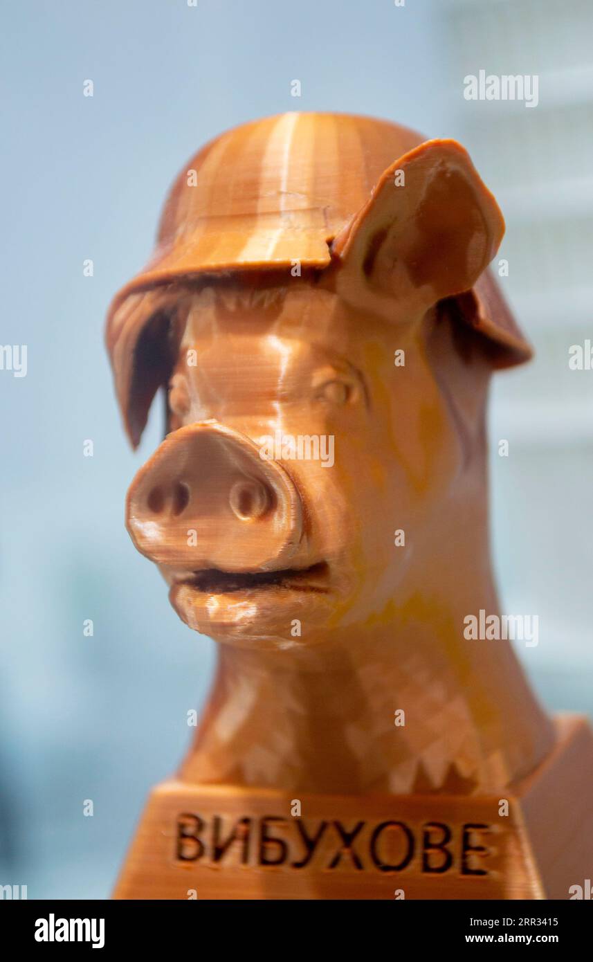 Art object printed on 3D printer. Prototype of a brown pig in a helmet ...