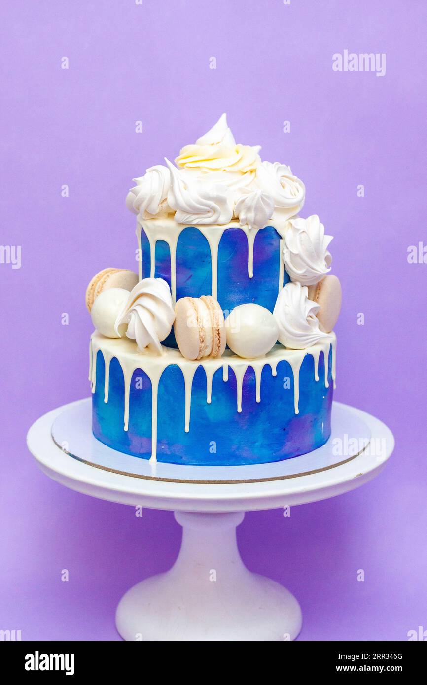 Layered blue cake on cake stand on a purple background. A picture for a ...