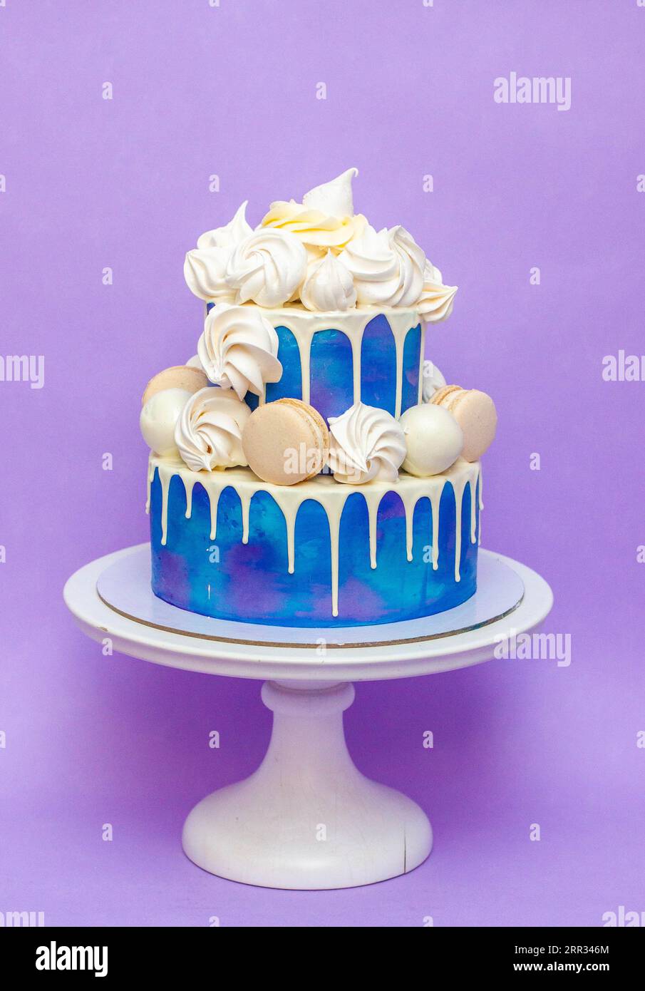 Layered blue cake on cake stand on a purple background. A picture for a ...