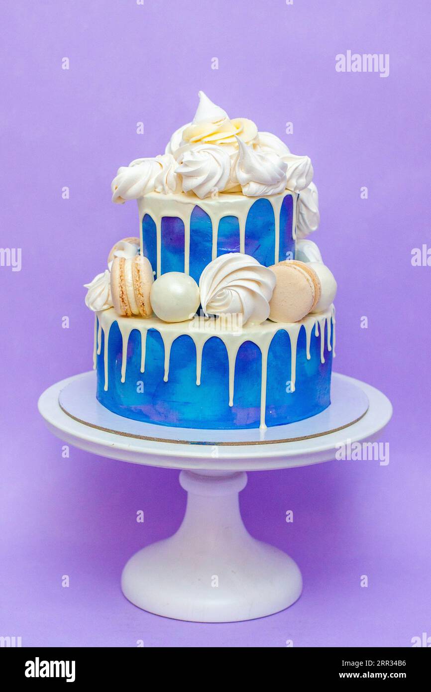 Layered blue cake on cake stand on a purple background. A picture for a ...