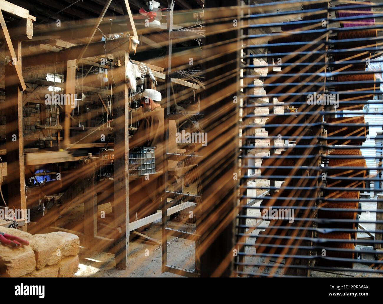 201024 -- PESHAWAR, Oct. 24, 2020 -- A man works at a traditional shawl ...