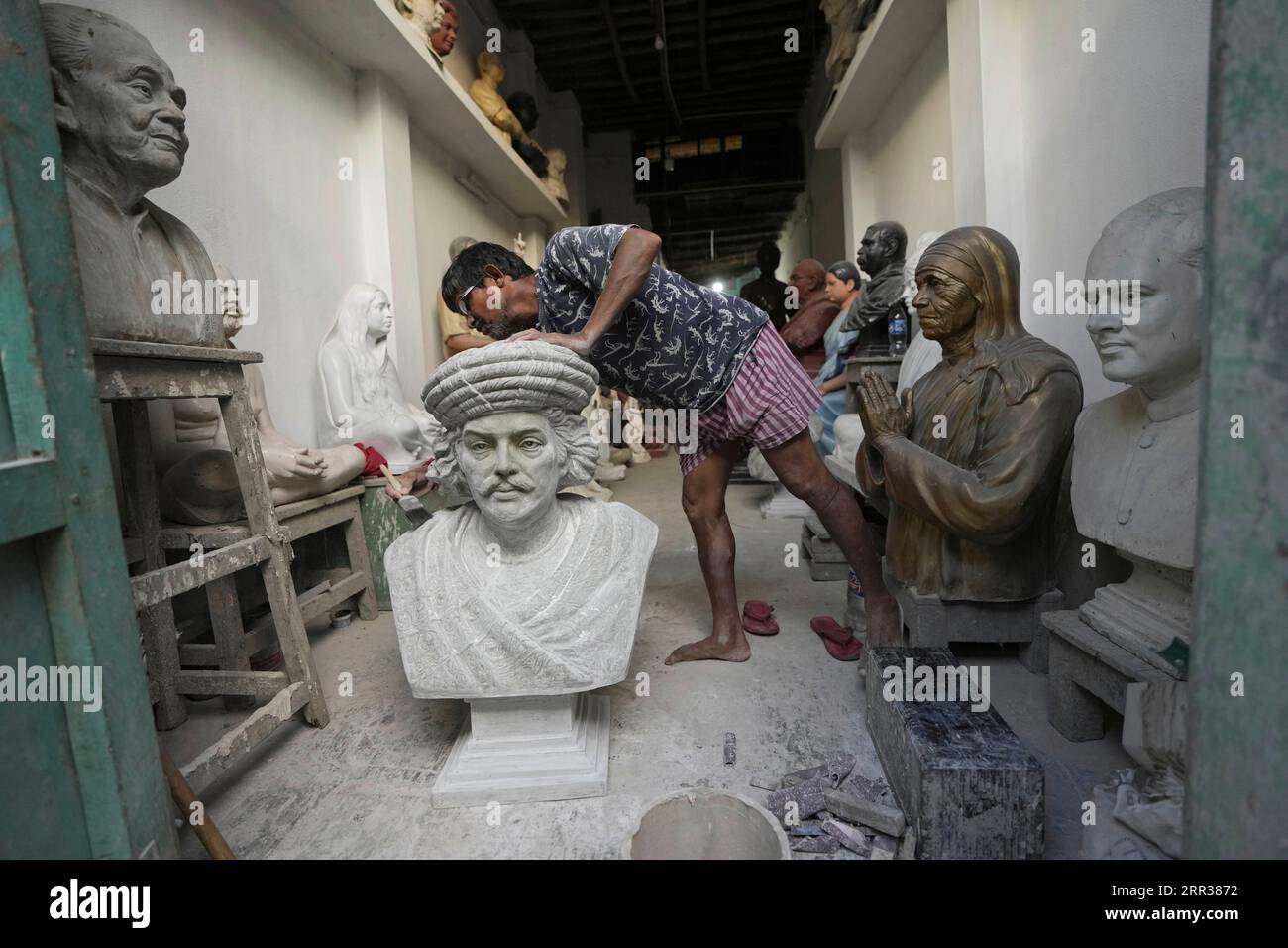An artist works on a bust of Raja Ram Mohan Roy besides busts of former ...