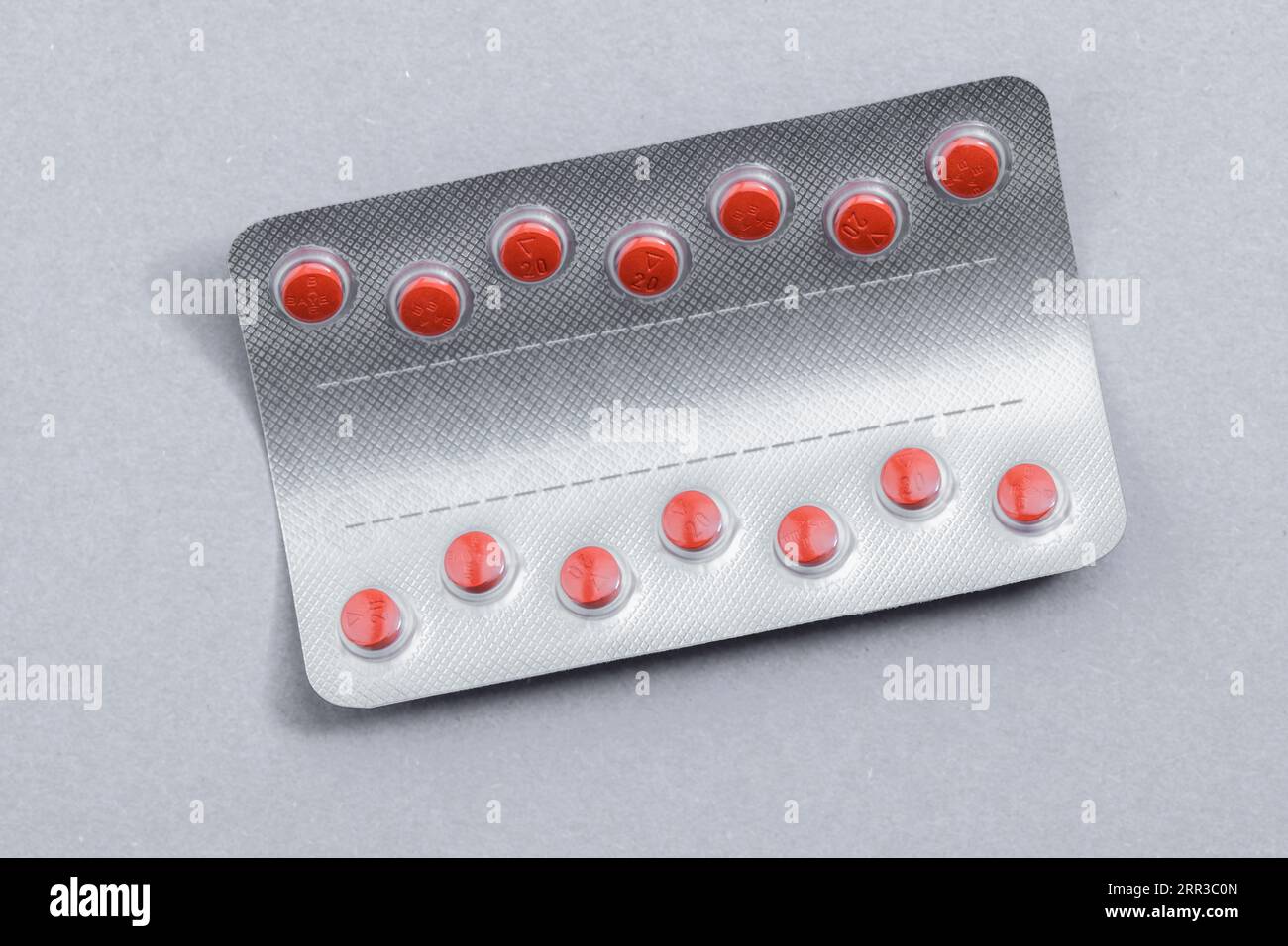 Packaging of red medicine pills on gray background. Global healthcare concept. Antibiotics drug ...