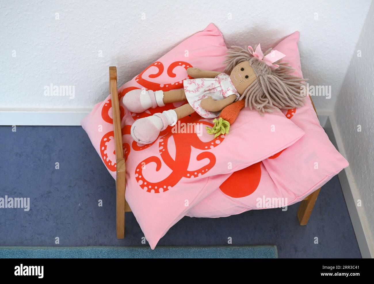 Berlin, Germany. 06th Sep, 2023. A girl's doll lies on a wooden toy bed ...