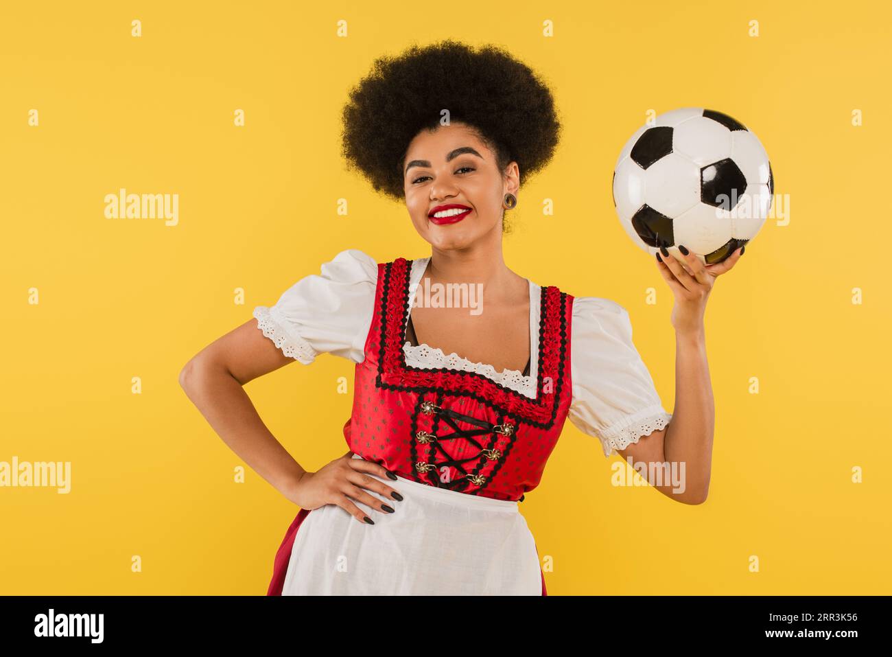 charming african american bavarian waitress posing with soccer ball and ...