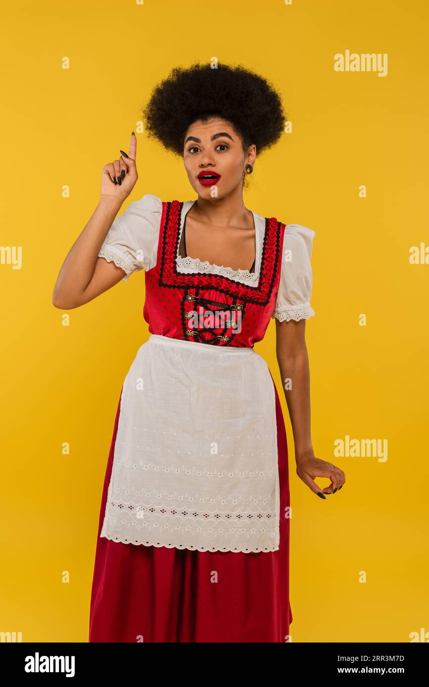 excited african american waitress in traditional bavarian costume ...