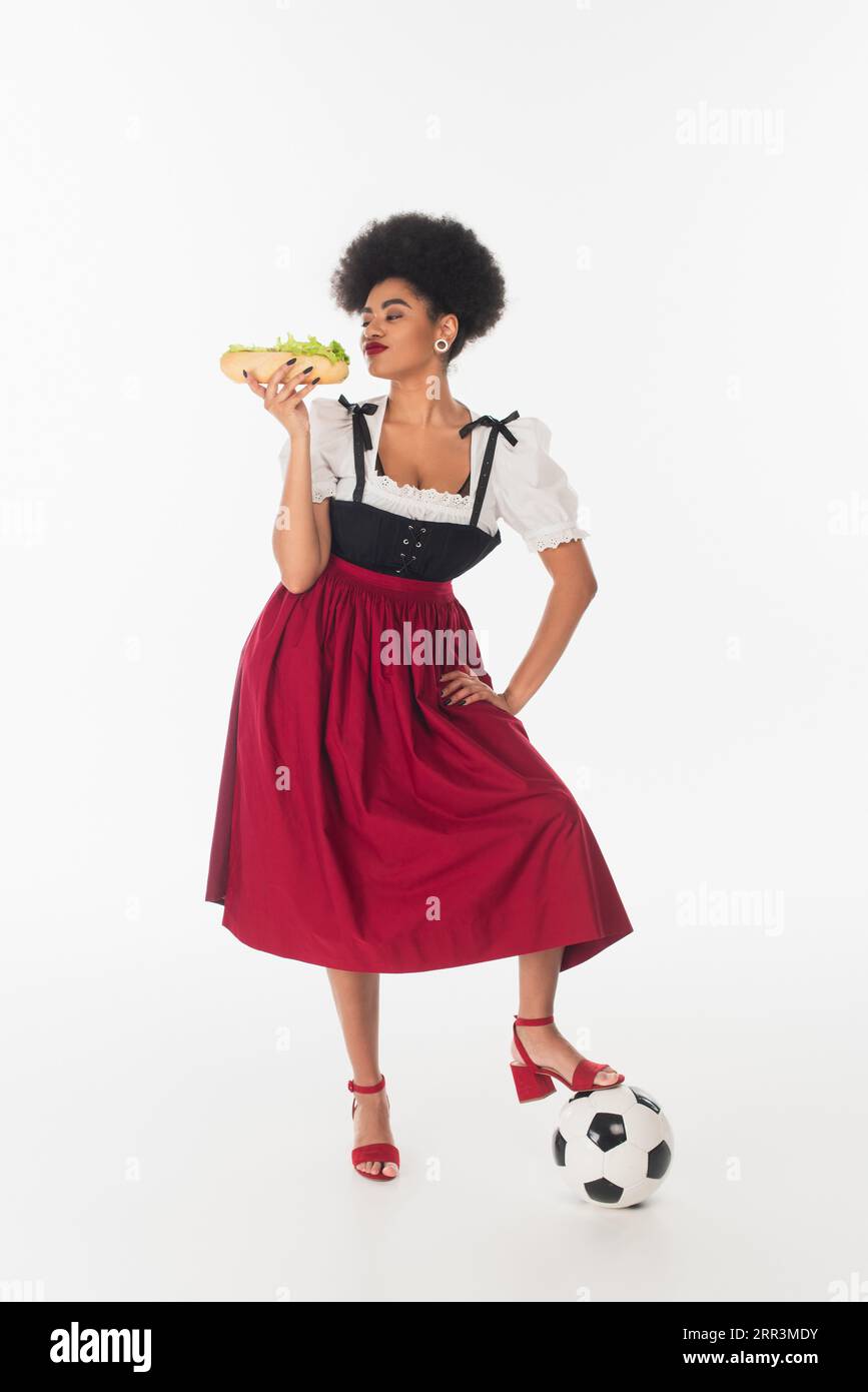 african american bavarian waitress posing with tasty hot dog and soccer ...