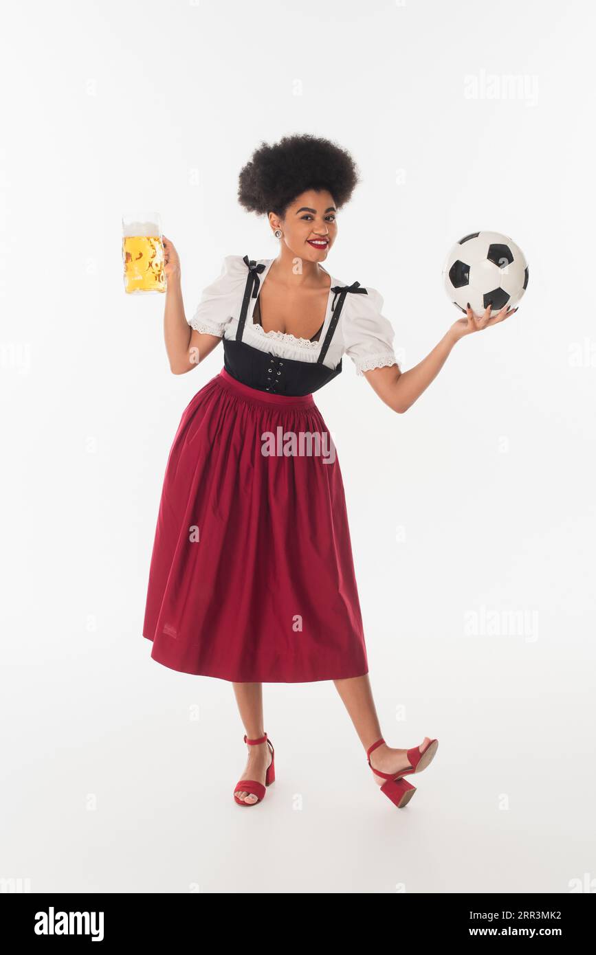 african american oktoberfest waitress with mug of foamy beer playing ...