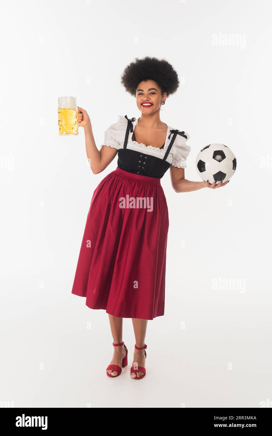 african american bavarian waitress posing with soccer ball and mug of ...