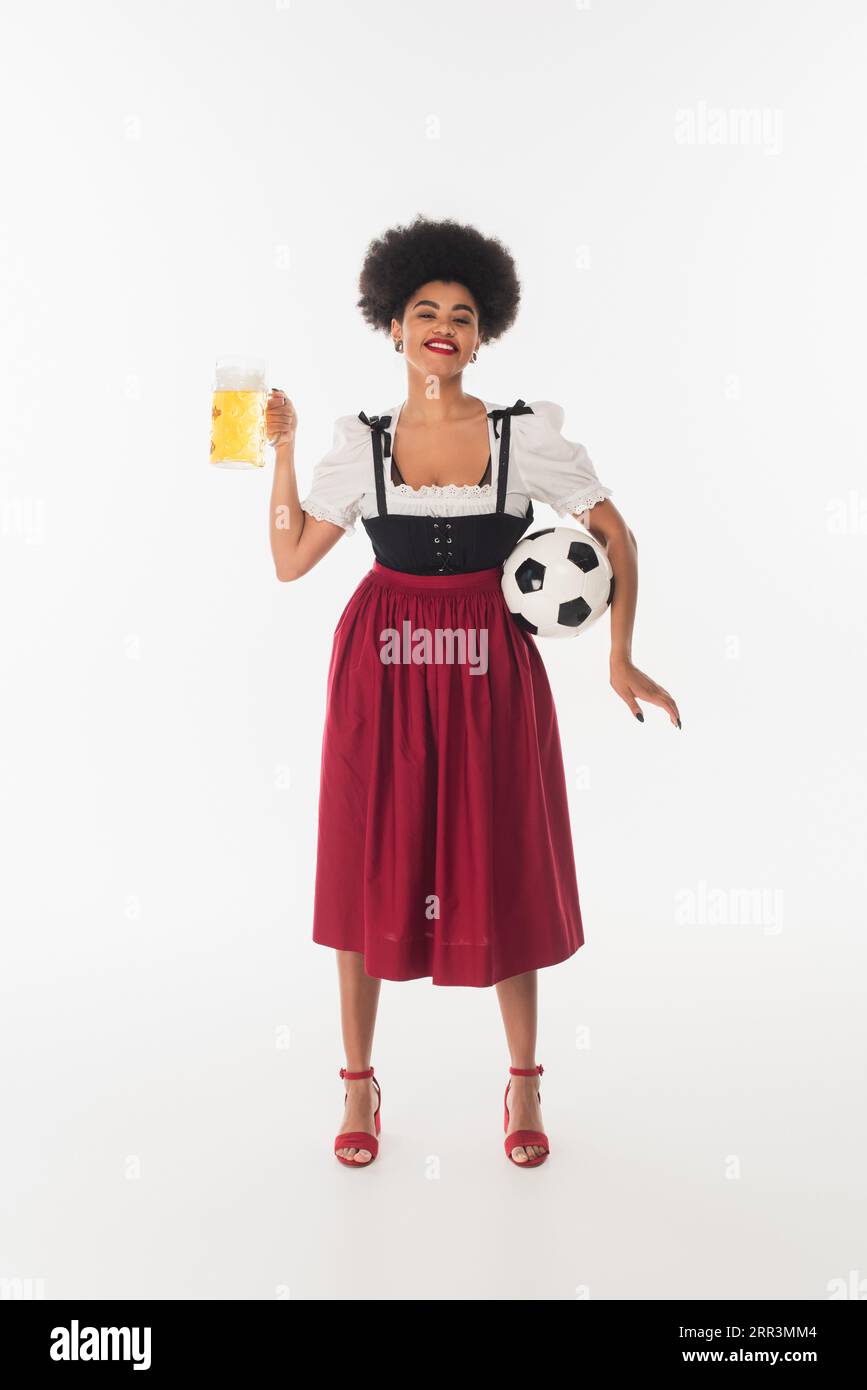 african american bavarian waitress with soccer ball and mug of beer ...