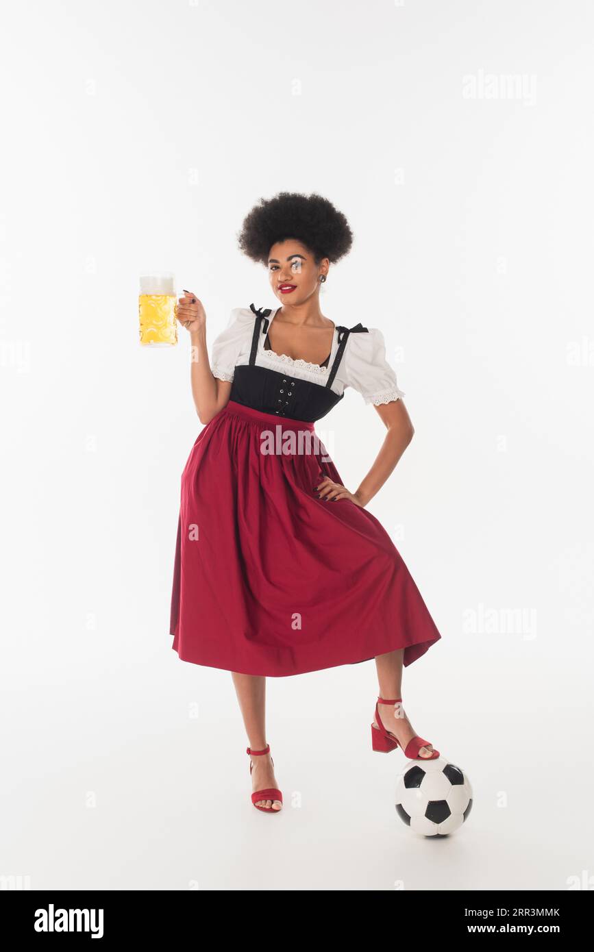 happy african american bavarian waitress posing with mug of beer with ...