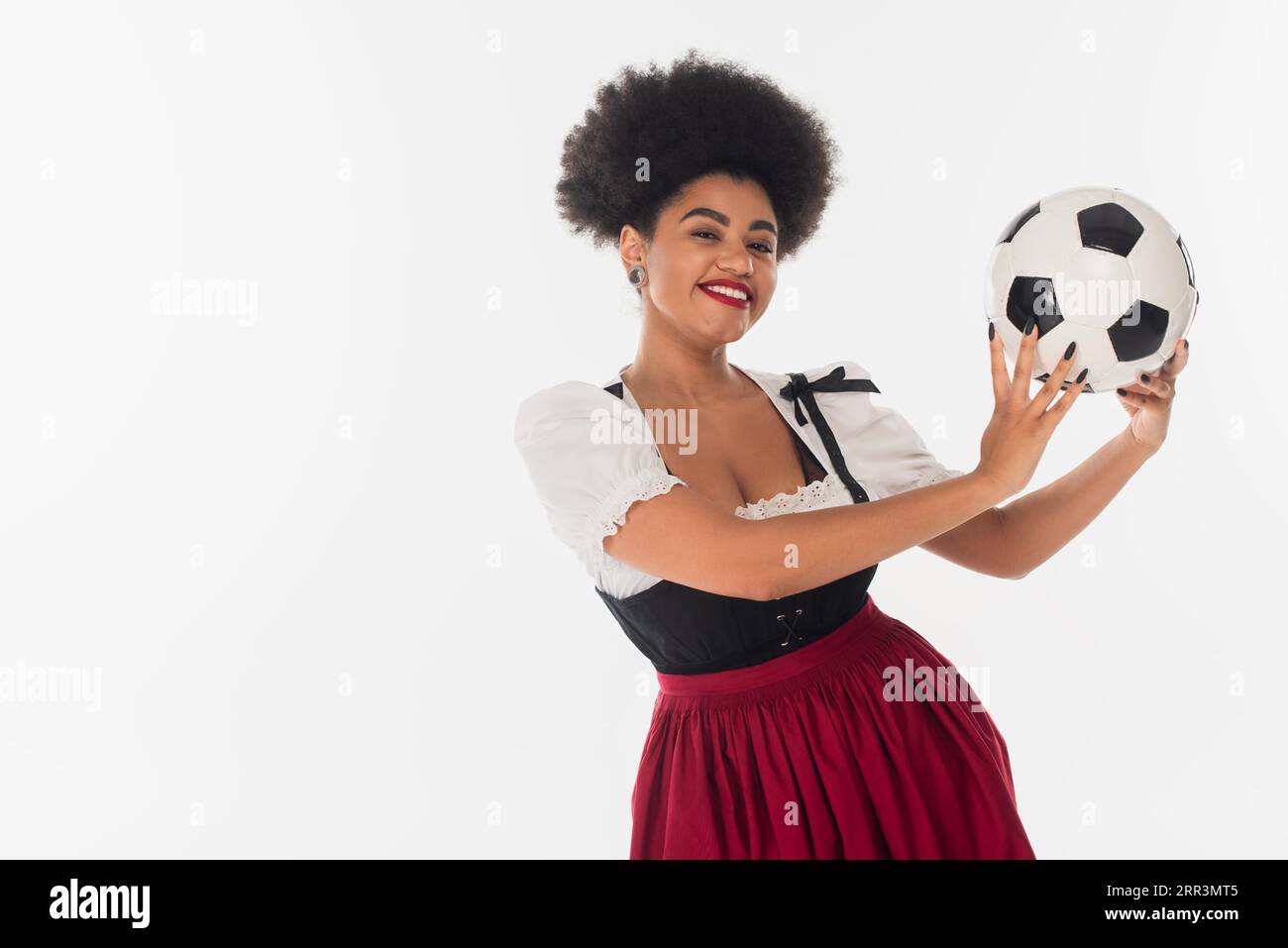 joyful octoberfest waitress in bavarian costume holding soccer ball ...