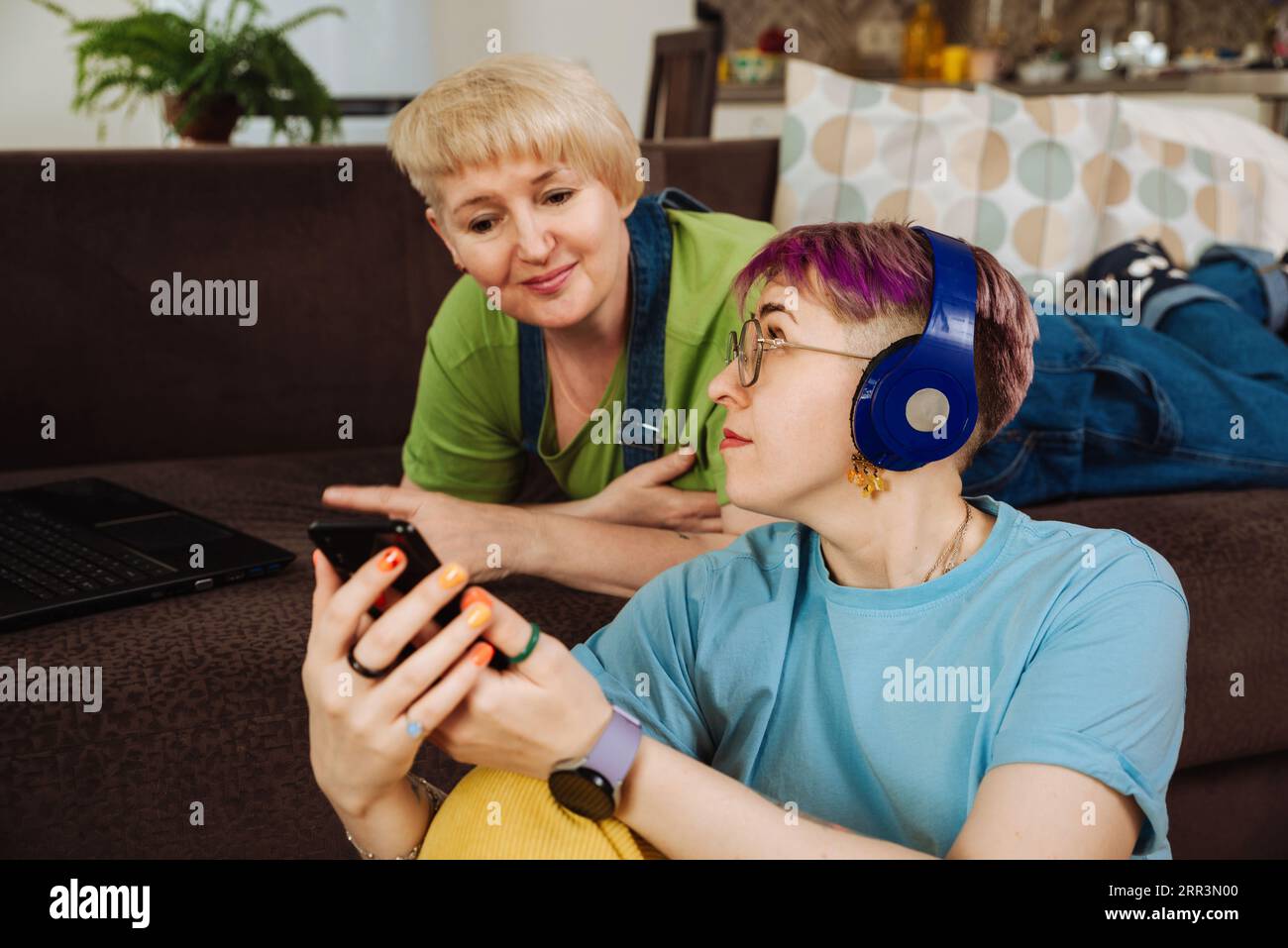 Daughter teaches her elderly mother how to use smartphone to listen to podcasts Stock Photo - Alamy