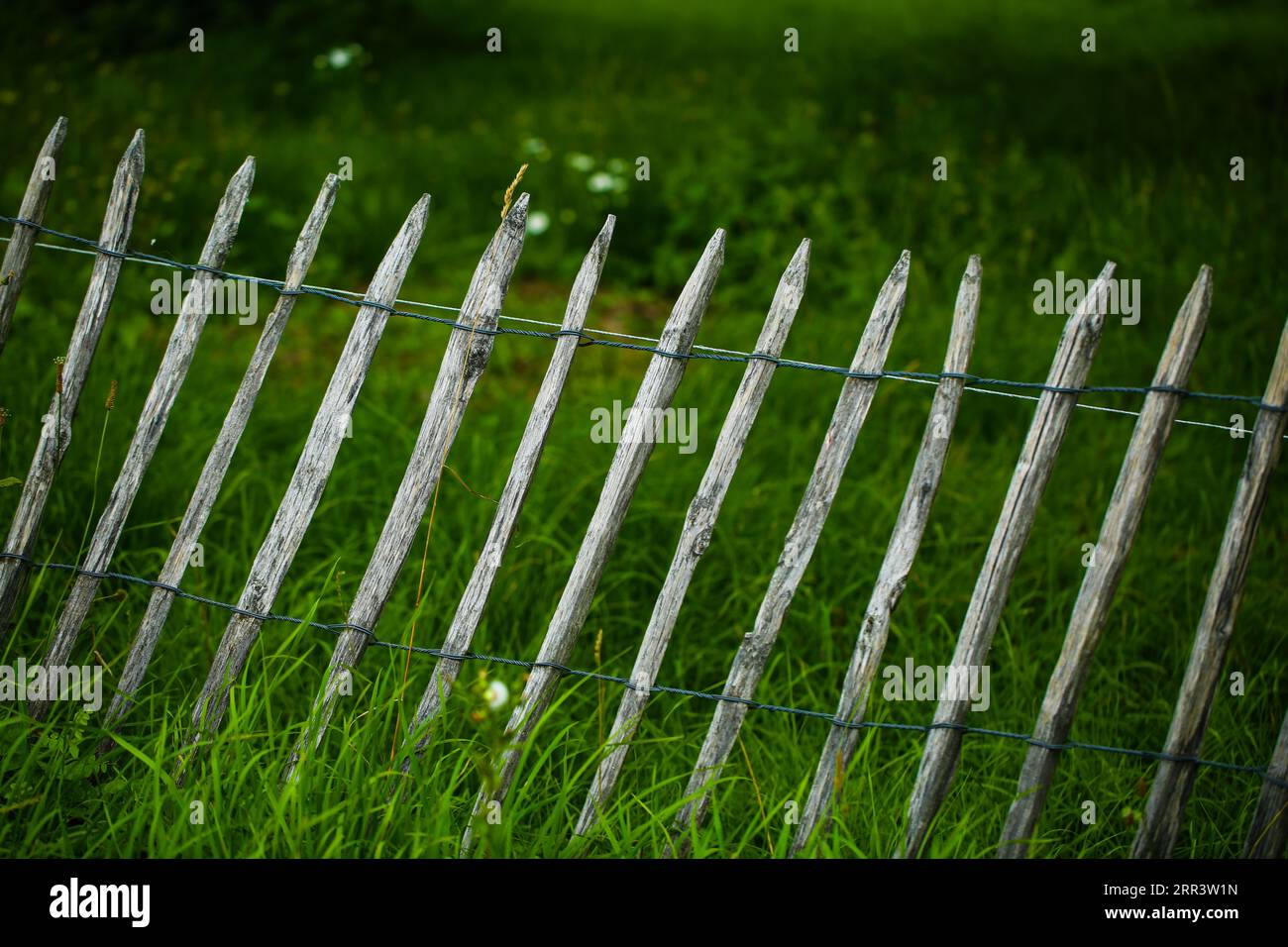 sloping wooden garden fence with meadow Stock Photo - Alamy