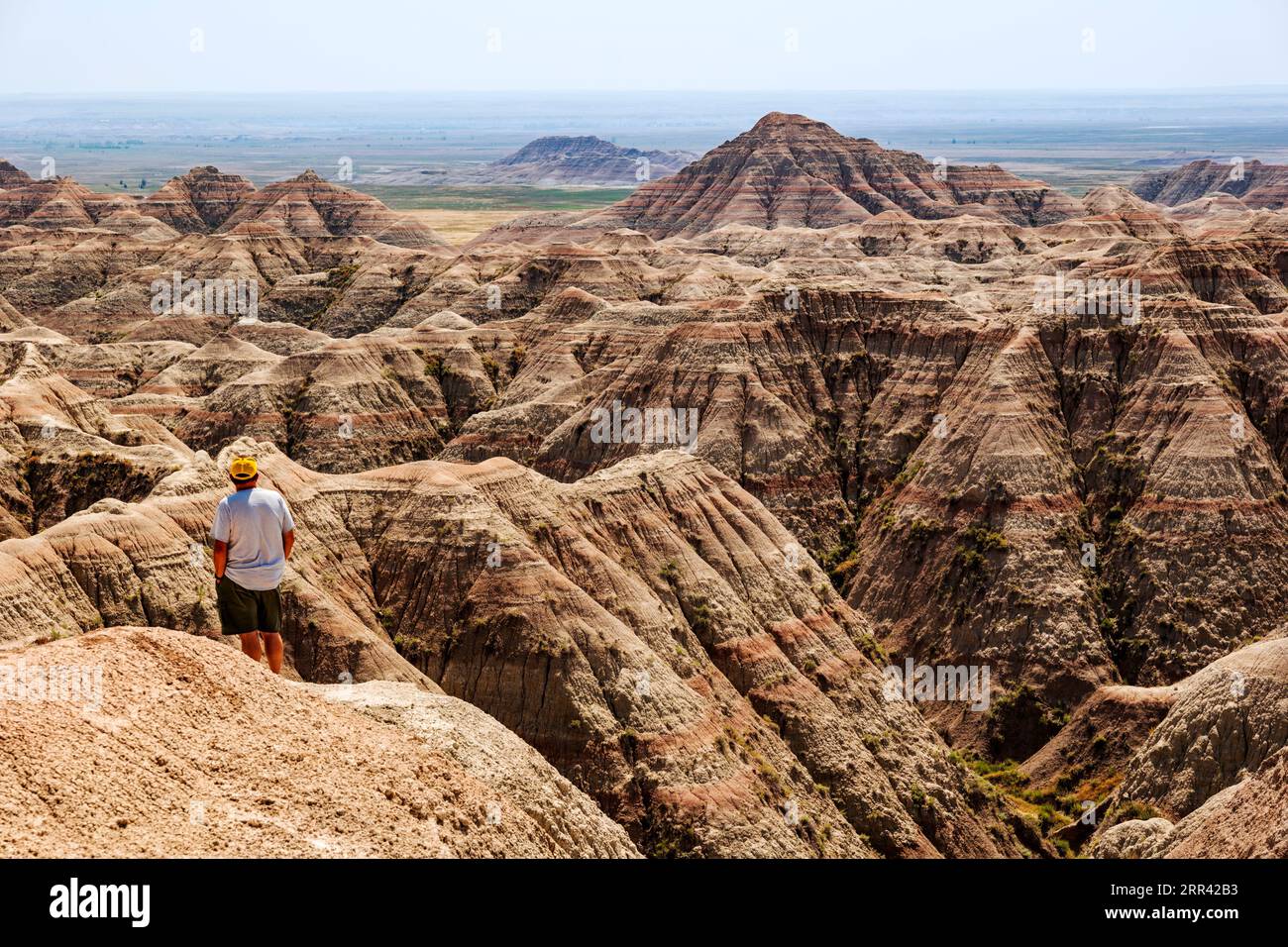 Male tourist visits Badlands National Park; White River Valley Overlook ...