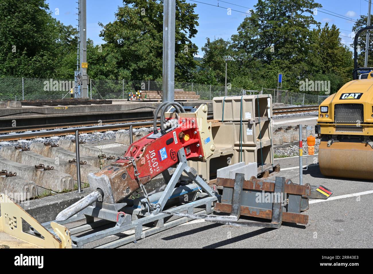 Red large construction machinery jack hammer and yellow tandem ...