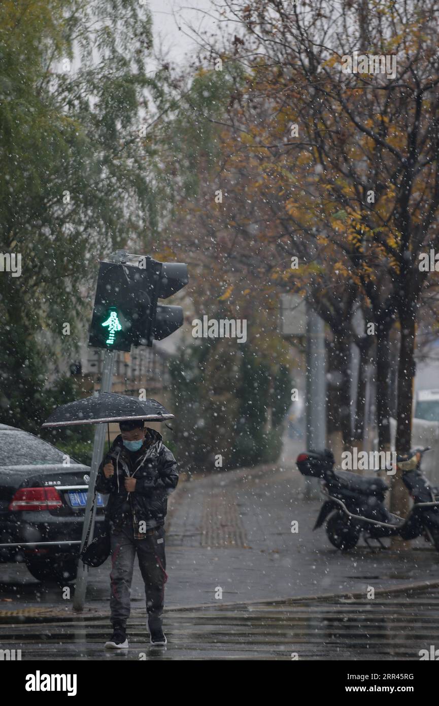 201121 -- BEIJING, Nov. 21, 2020 -- A man crosses a road in the snow in ...