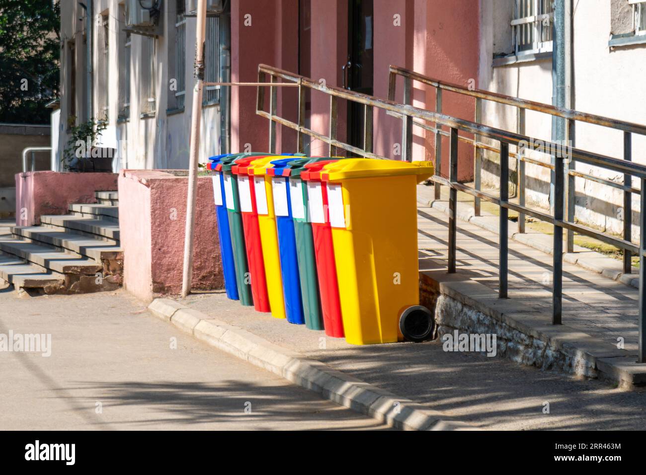 Garbage trash bins multicolor red, yellow, green, blue in school yard ...