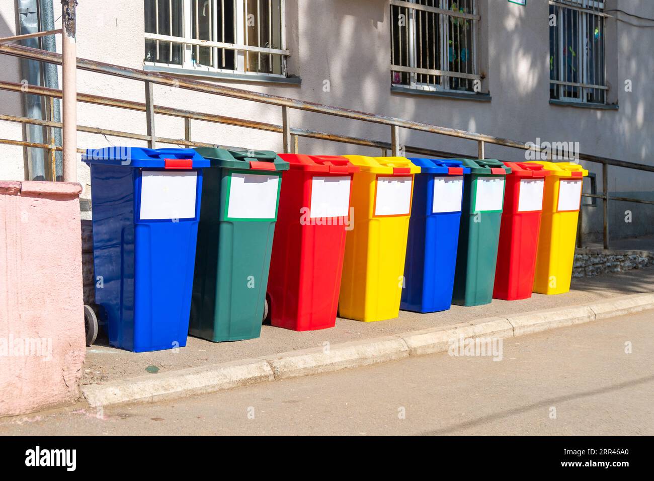 Garbage trash bins multicolor red, yellow, green, blue in school yard ...