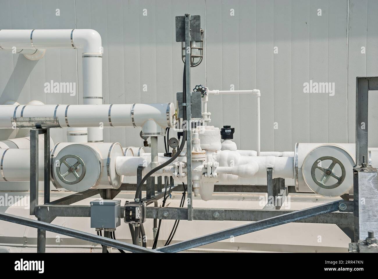 White insulated piping mounted on roof of cold storage facility, for ...