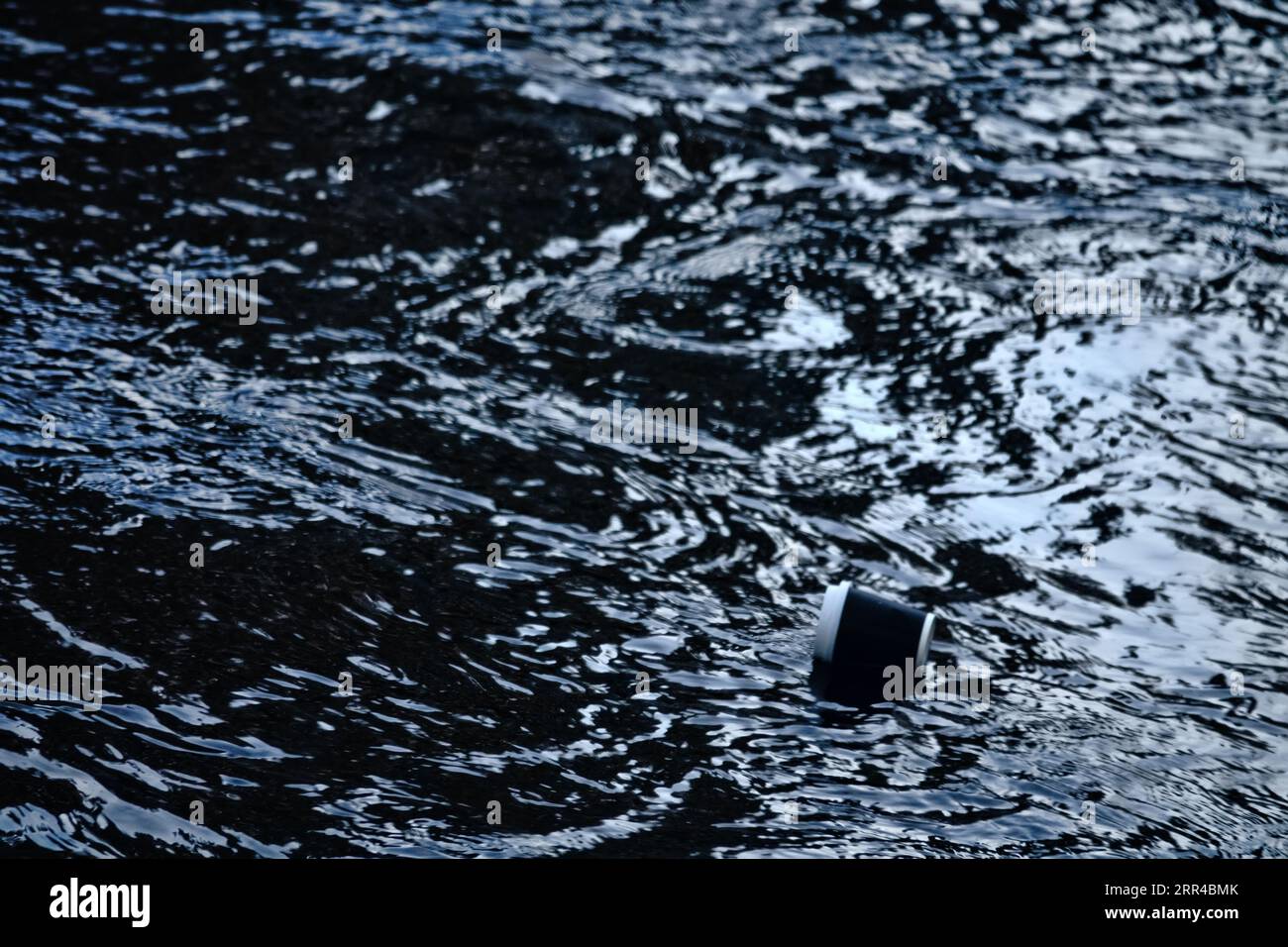 An empty plastic cup floats on the river Stock Photo - Alamy