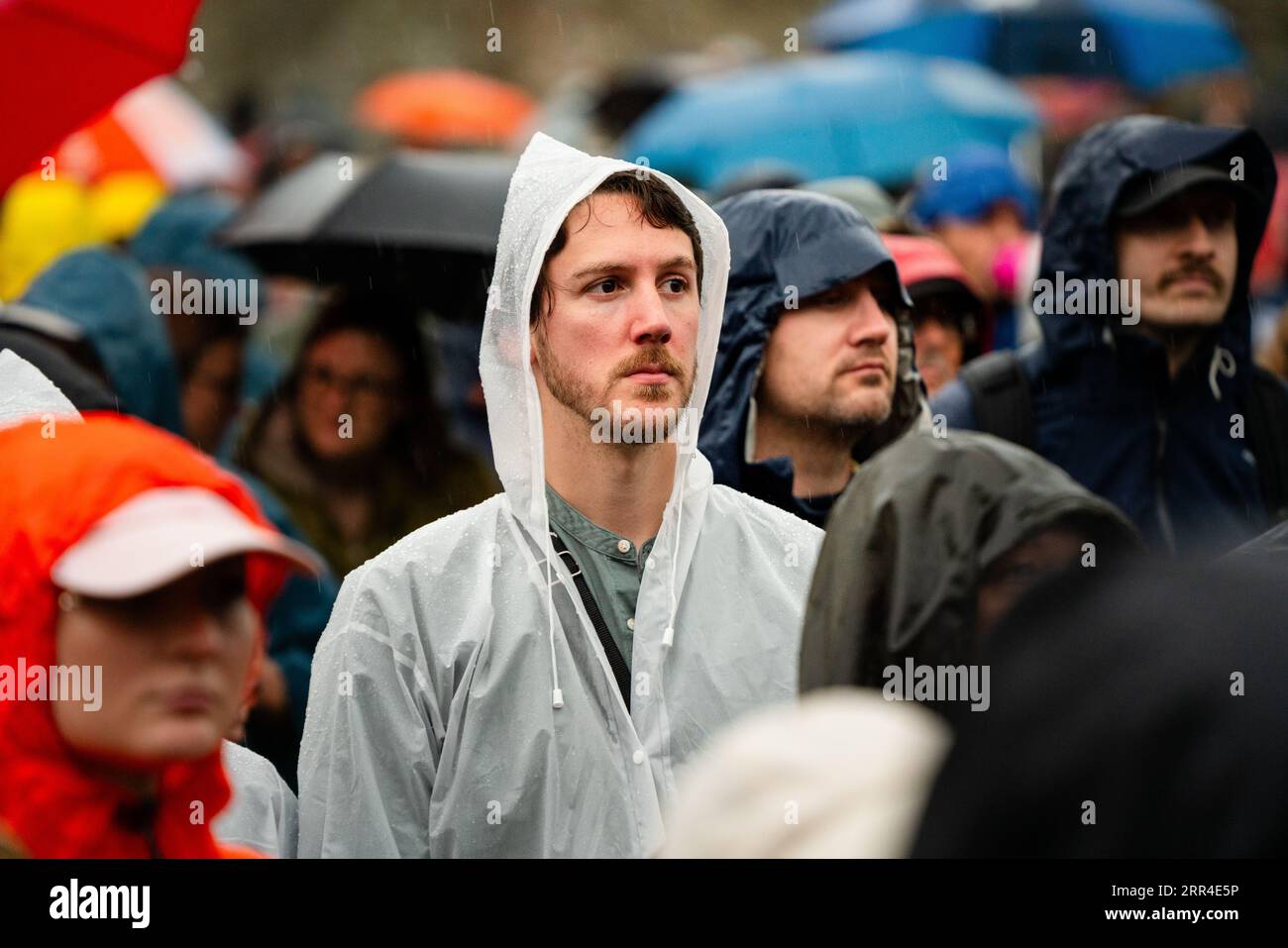 A man in a poncho in the rainstorm rain and mud. Green Man Festival ...