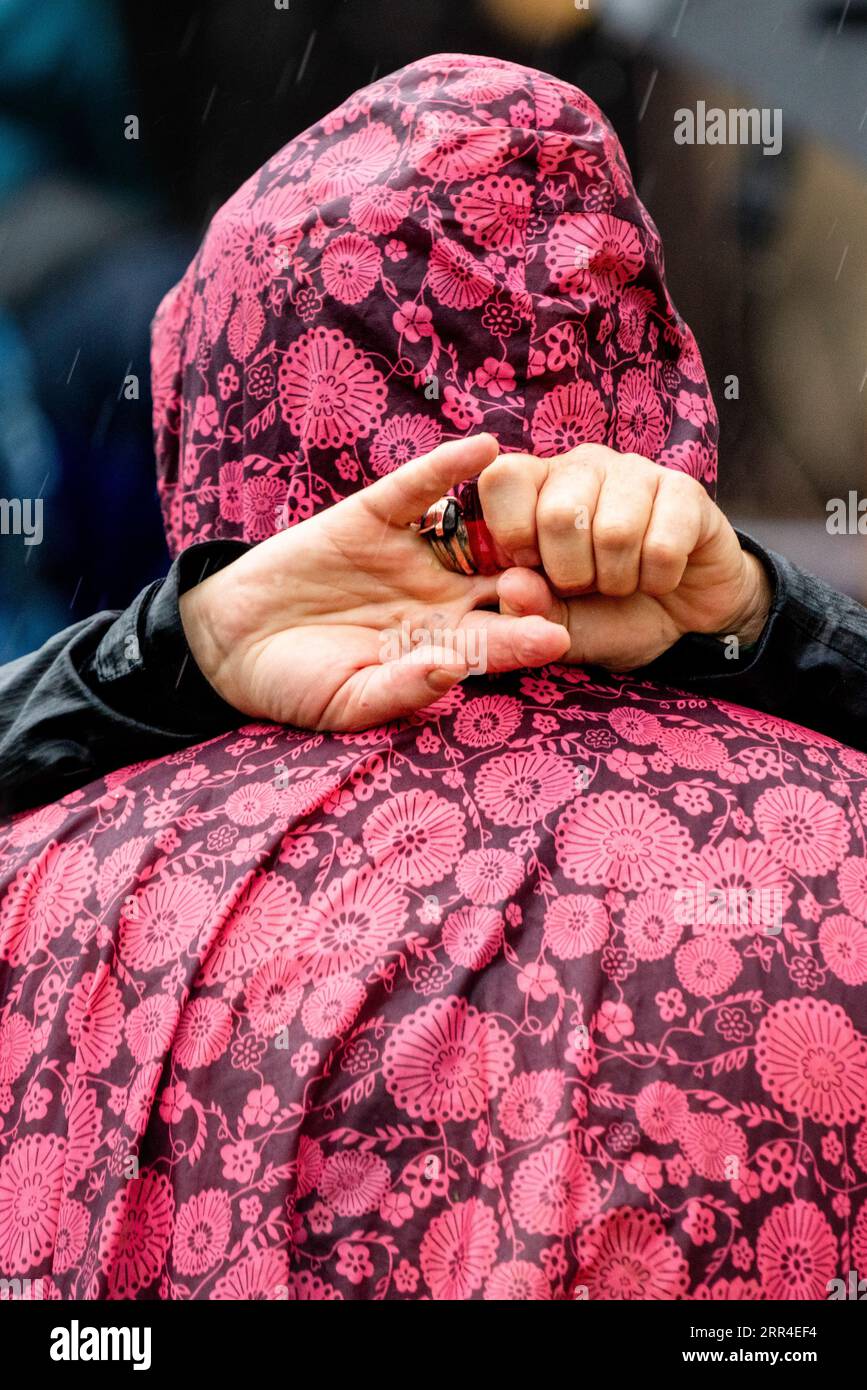A faceless romantic couple dancing in rain clothes in the rain. Green ...