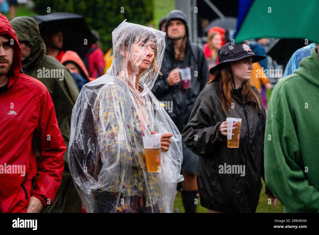 A middle age woman in wets with beer in the rainstorn rain and mud ...