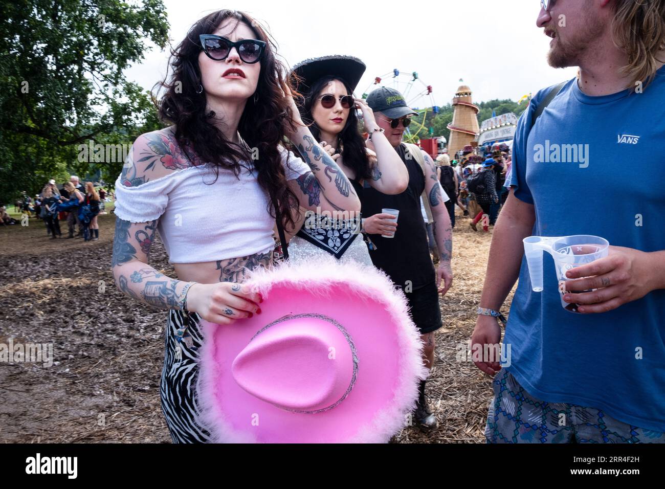 A glamorous woman goth with a bright pink hat and shades at Green Man ...