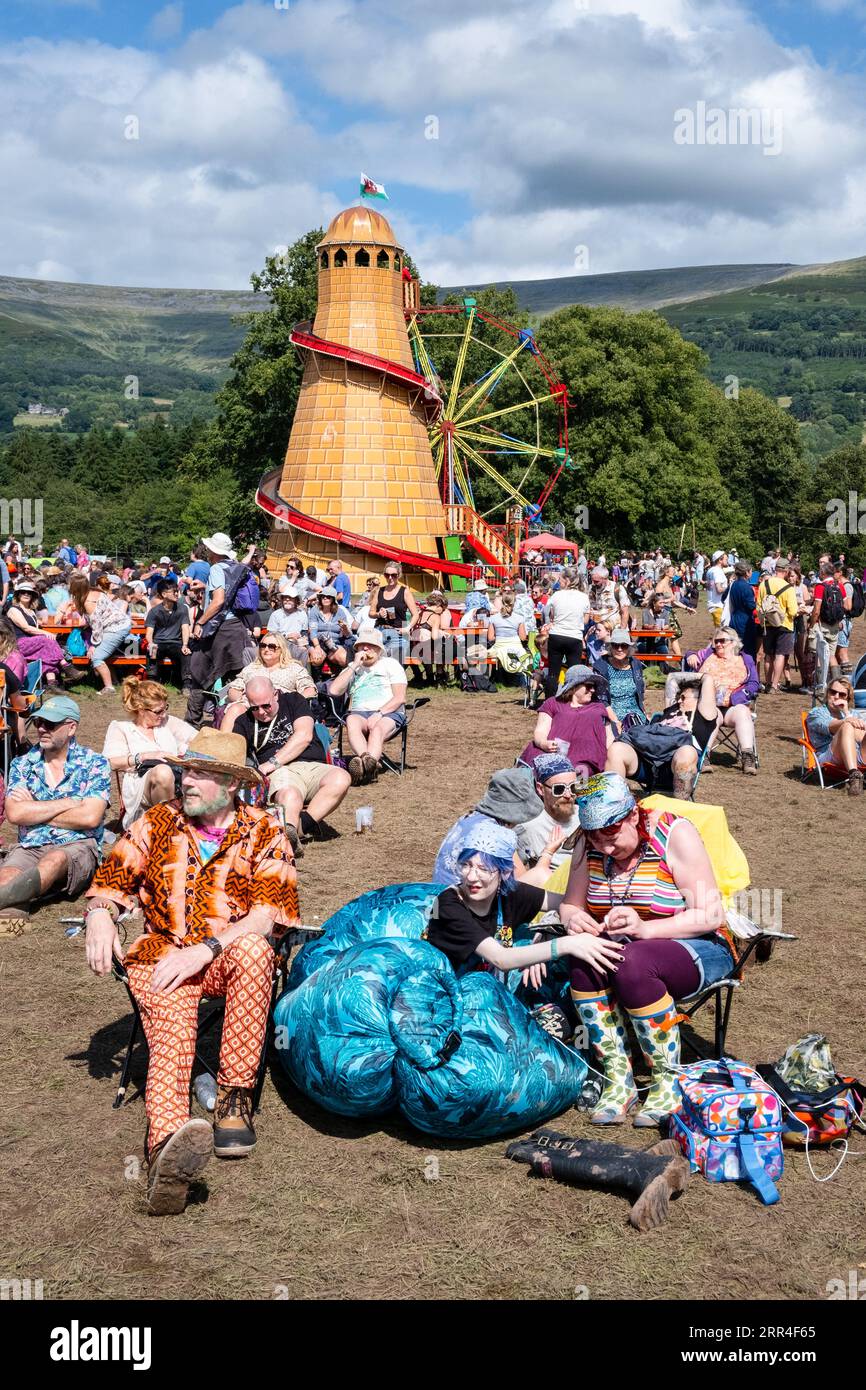 The colourful crowd in the fairground area in front of the Far Out ...
