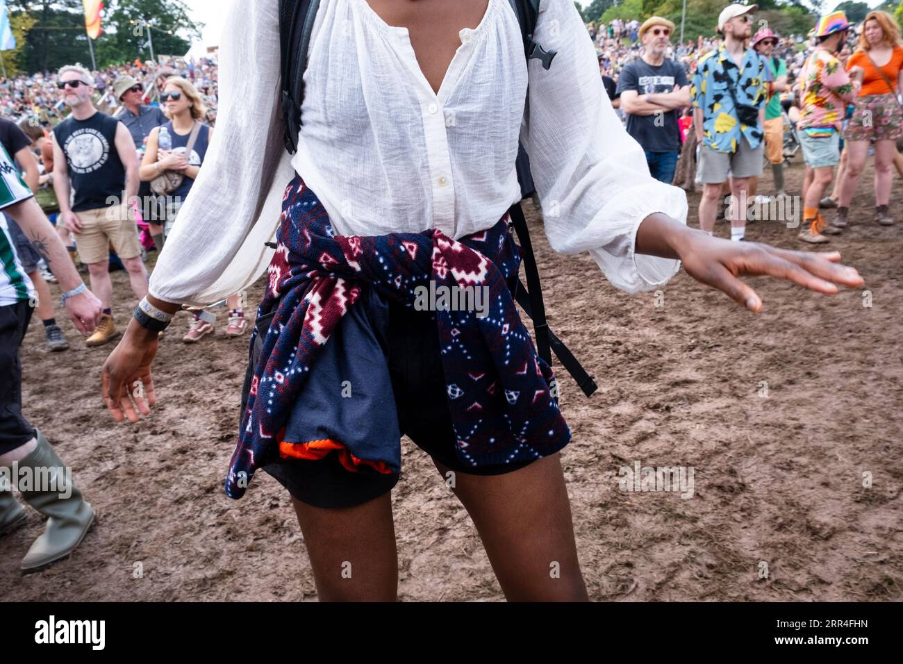 A faceless woman dancing in the mud in sunshine after the rain at Green ...