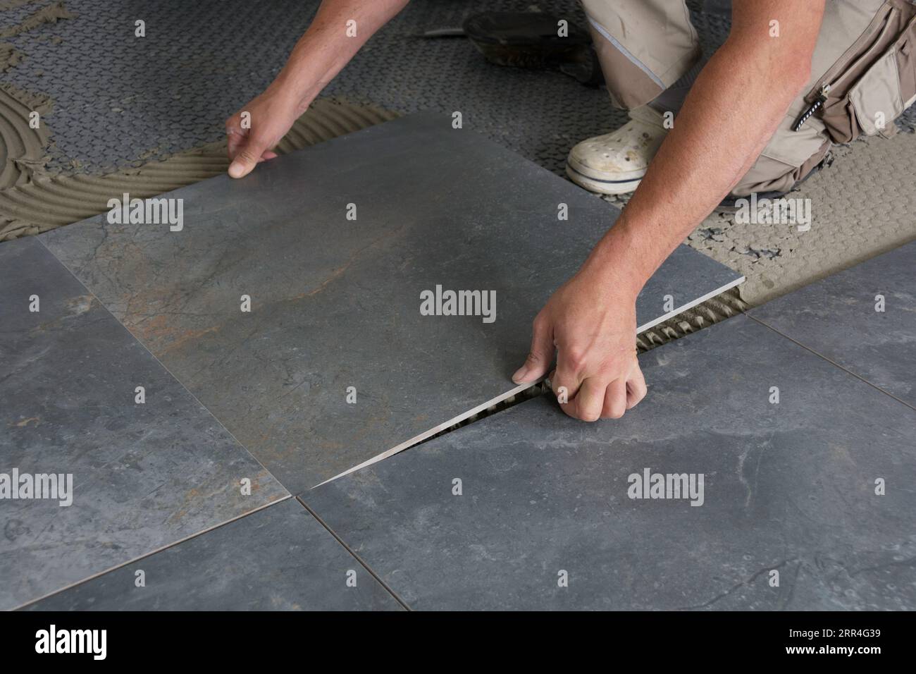 A Tiler laid floor tile Stock Photo - Alamy