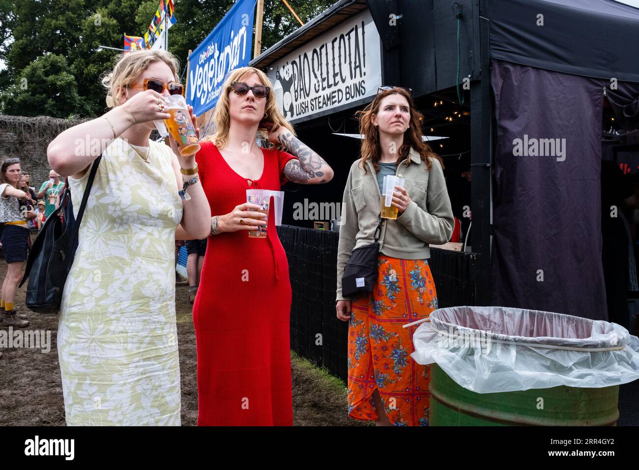 Three young women drinking pints beers in smart clothes dresses at ...