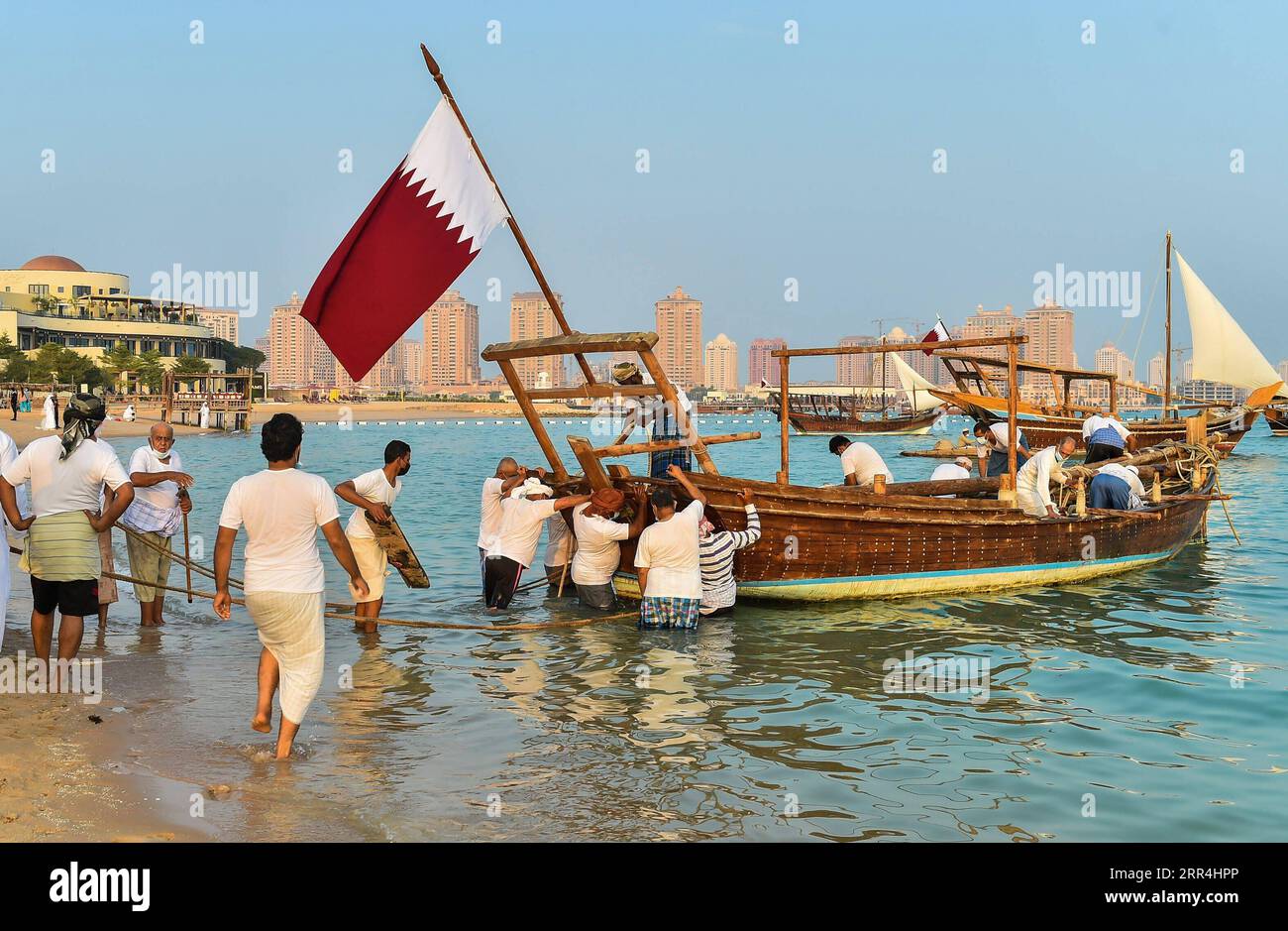 201205 -- DOHA, Dec. 5, 2020 -- People prepare to launch a dhow into ...