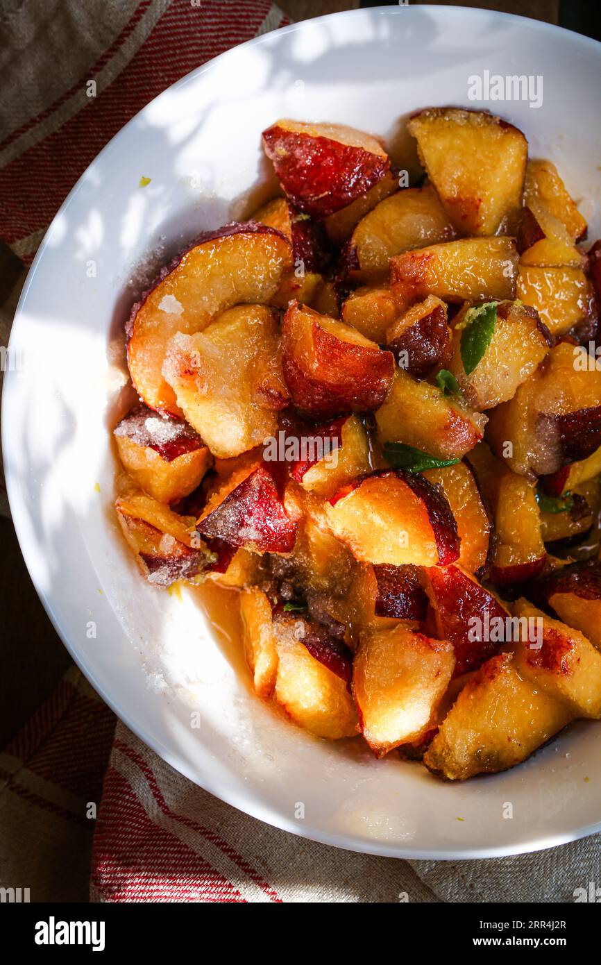 Diced peaches with sugar and lemon verbena leaves. preparation for jam ...