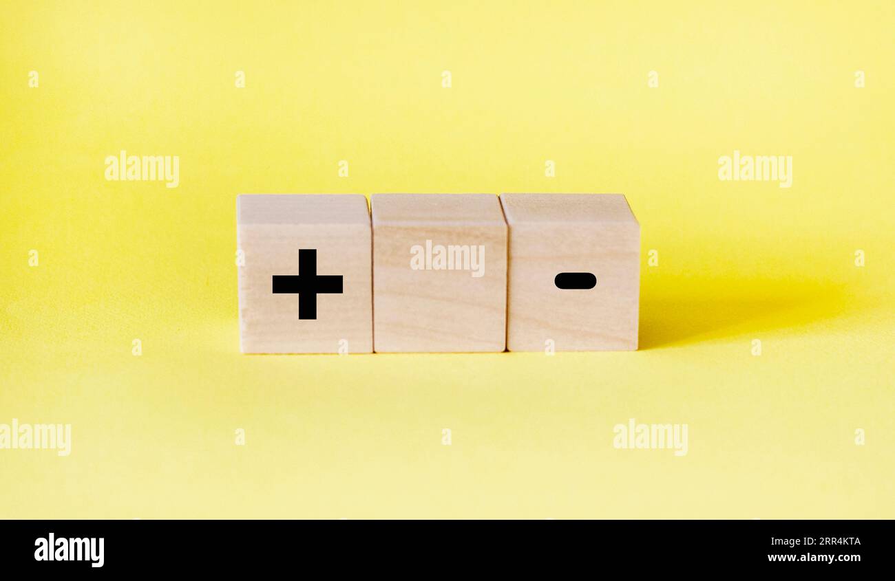 blocks on a yellow background with a plus and a minus. Choice concept ...