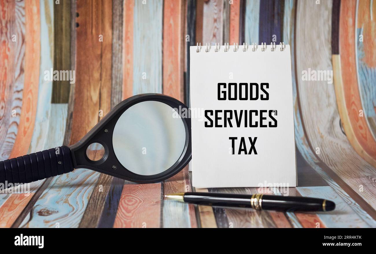 Goods service tax text in a notepad next to a magnifying glass and a ...