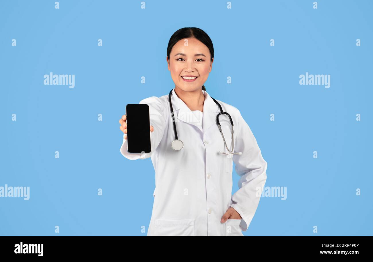 Medical Services. Smiling Asian Doctor Lady Holding Smartphone With ...