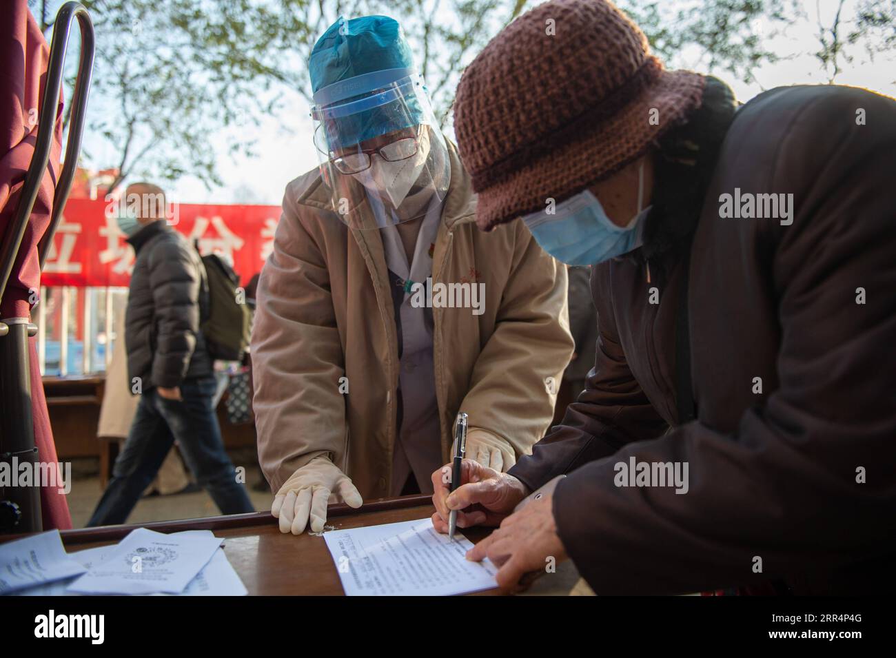 201210 -- BEIJING, Dec. 10, 2020 -- A staff member helps a senior ...