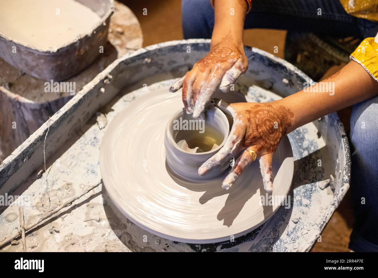 A female learning pottery using clay on potter's wheel Stock Photo - Alamy